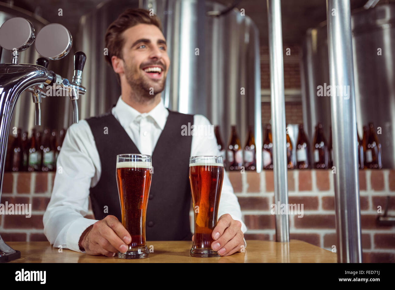 Handsome barman giving two beers Stock Photo - Alamy