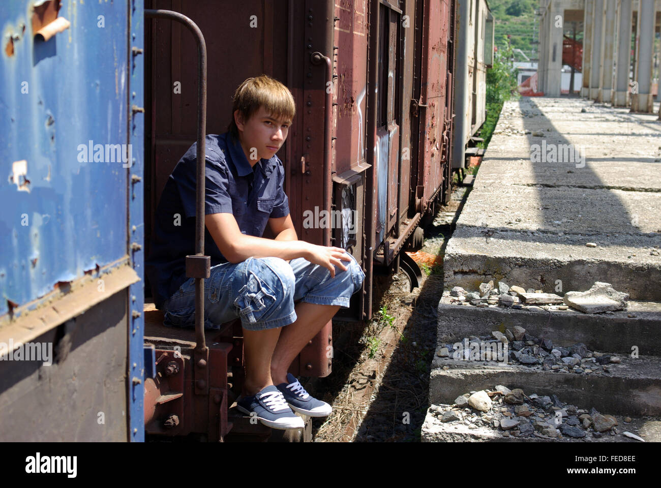 Boy in abandoned train station Stock Photo - Alamy