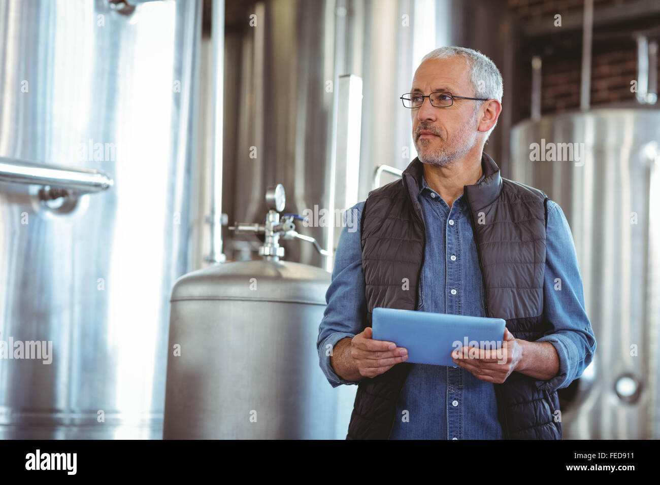 Local brewer using his tablet pc Stock Photo - Alamy
