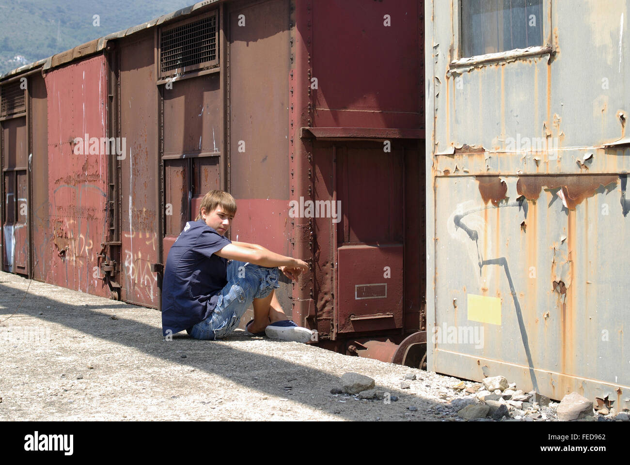 Boy in abandoned train station Stock Photo - Alamy