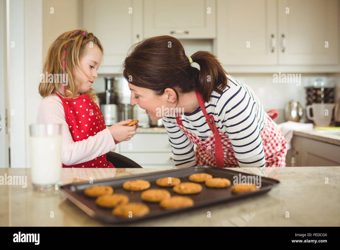 Daughter feeding cookie to mother Stock Photo - Alamy
