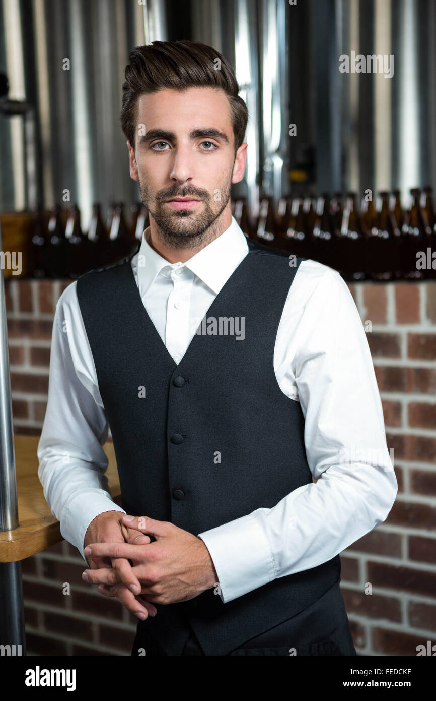 Handsome bar tender leaning on counter Stock Photo - Alamy