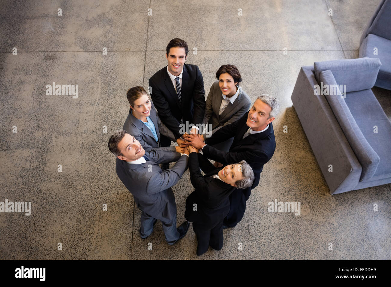 Smiling business people putting hands hi-res stock photography and ...