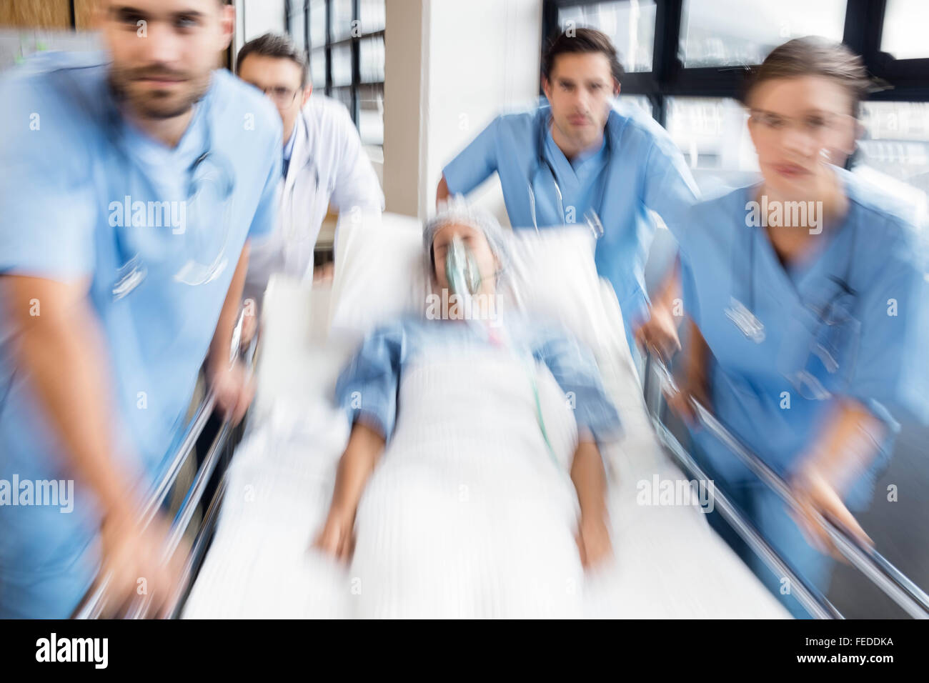 Medical team pushing patient on trolley Stock Photo - Alamy