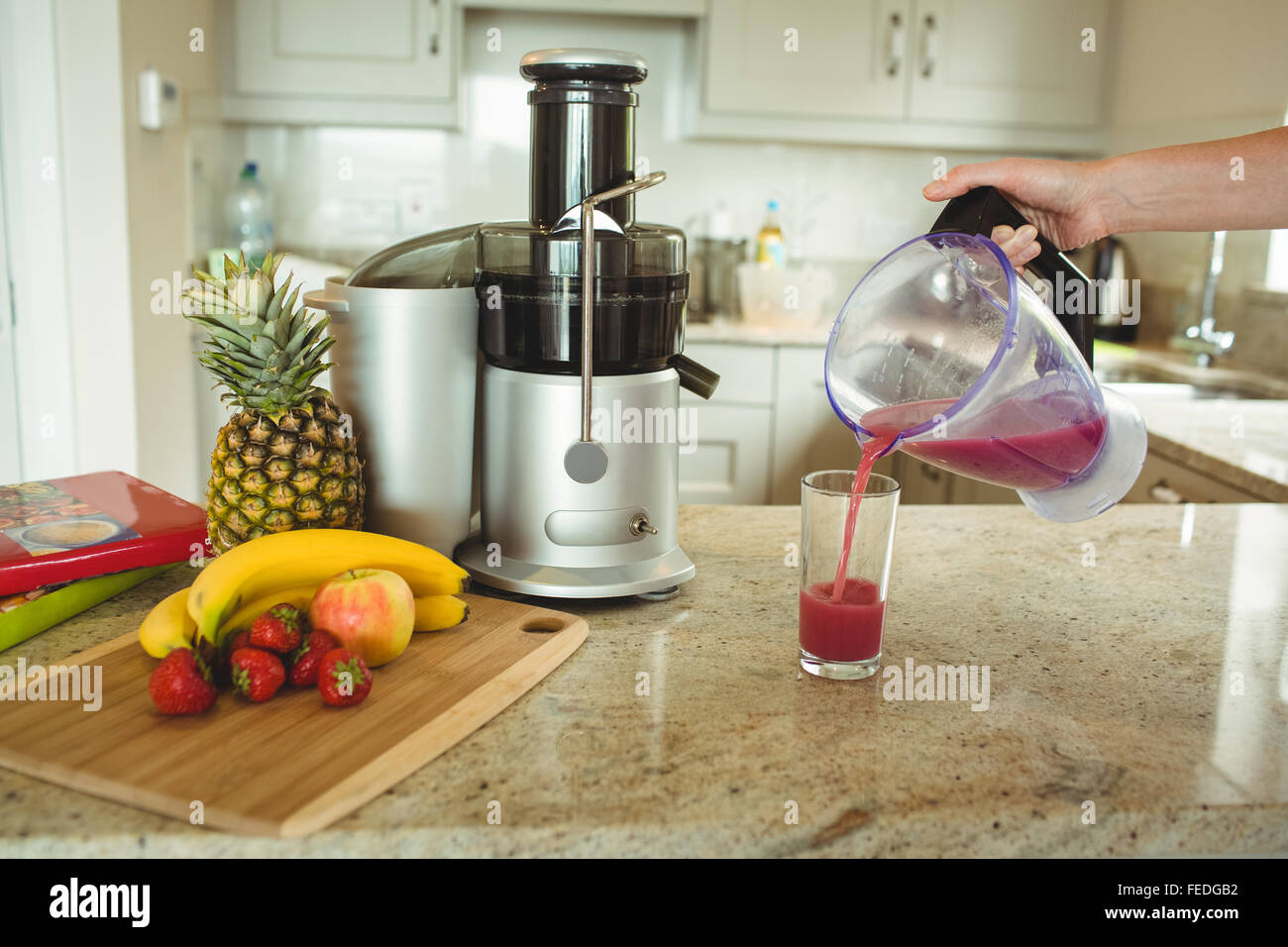 Pouring smoothie into glass Stock Photo - Alamy