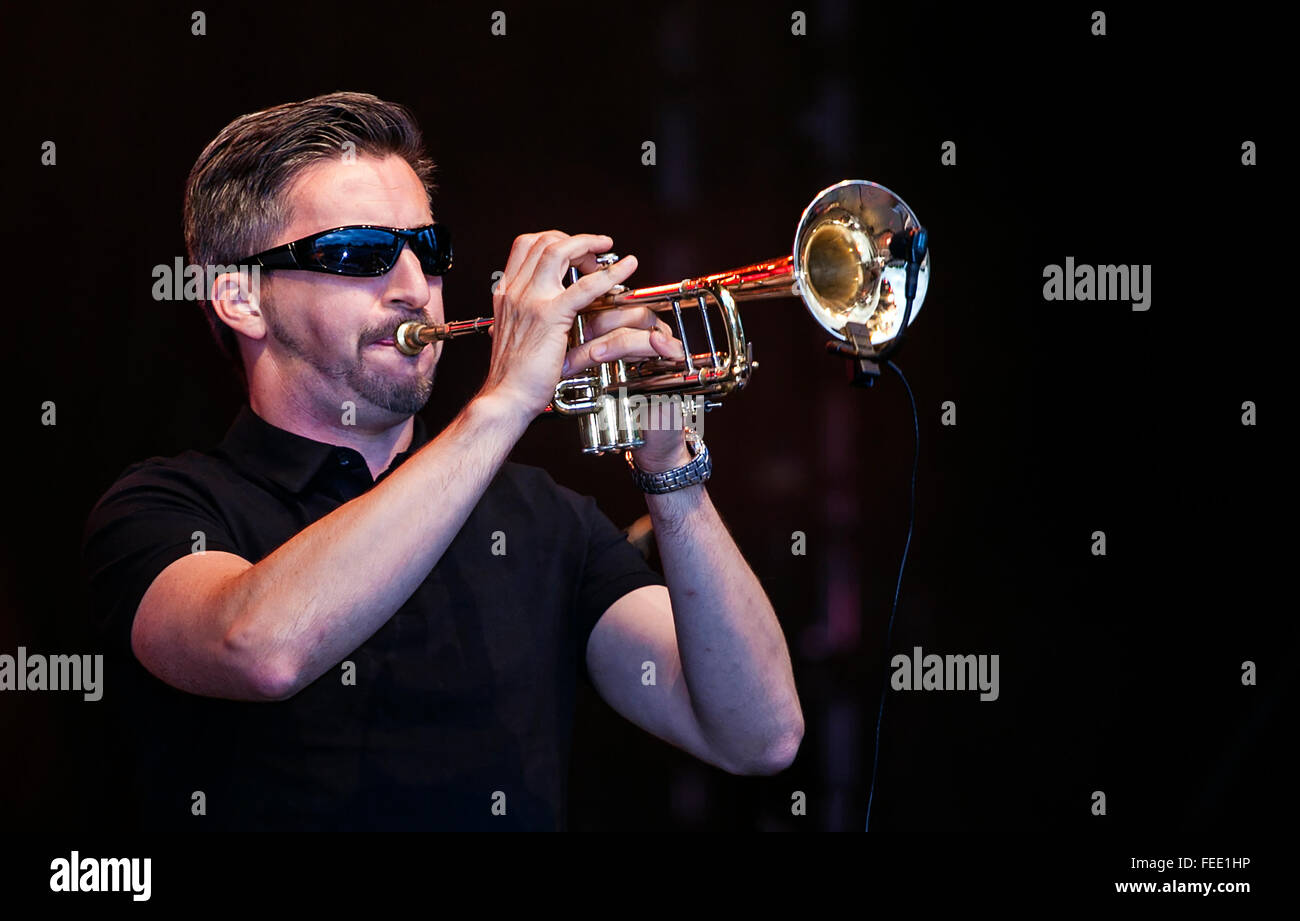Man playing a trumpet on stage wearing dark glass's Stock Photo - Alamy