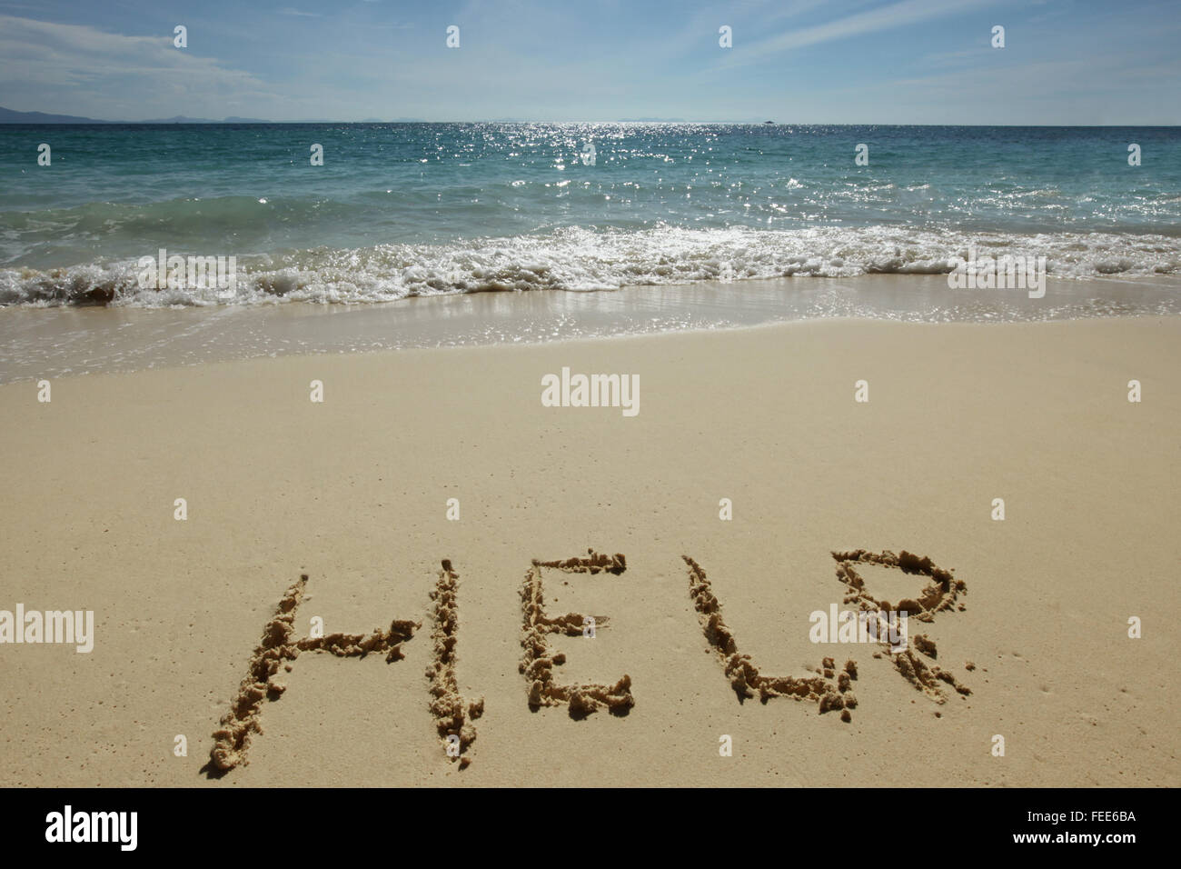 Help Sign on the sand of tropical sea beach Stock Photo - Alamy