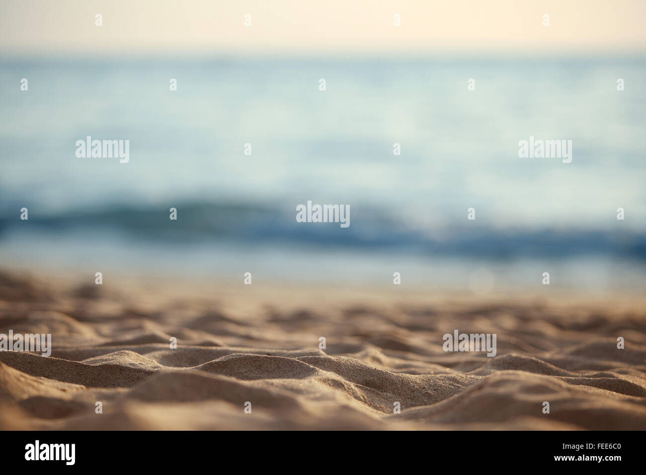 Close up of sand of beach with blurred sea background Stock Photo - Alamy