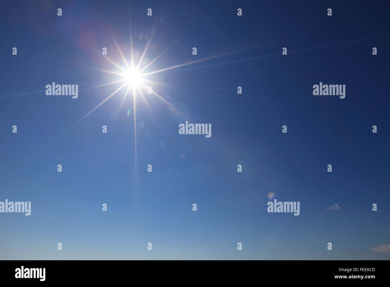 Sun with lens flare in clear blue sky Stock Photo - Alamy