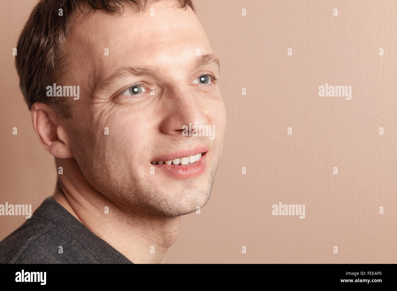 Young smiling handsome Caucasian man, close-up studio portrait over ...