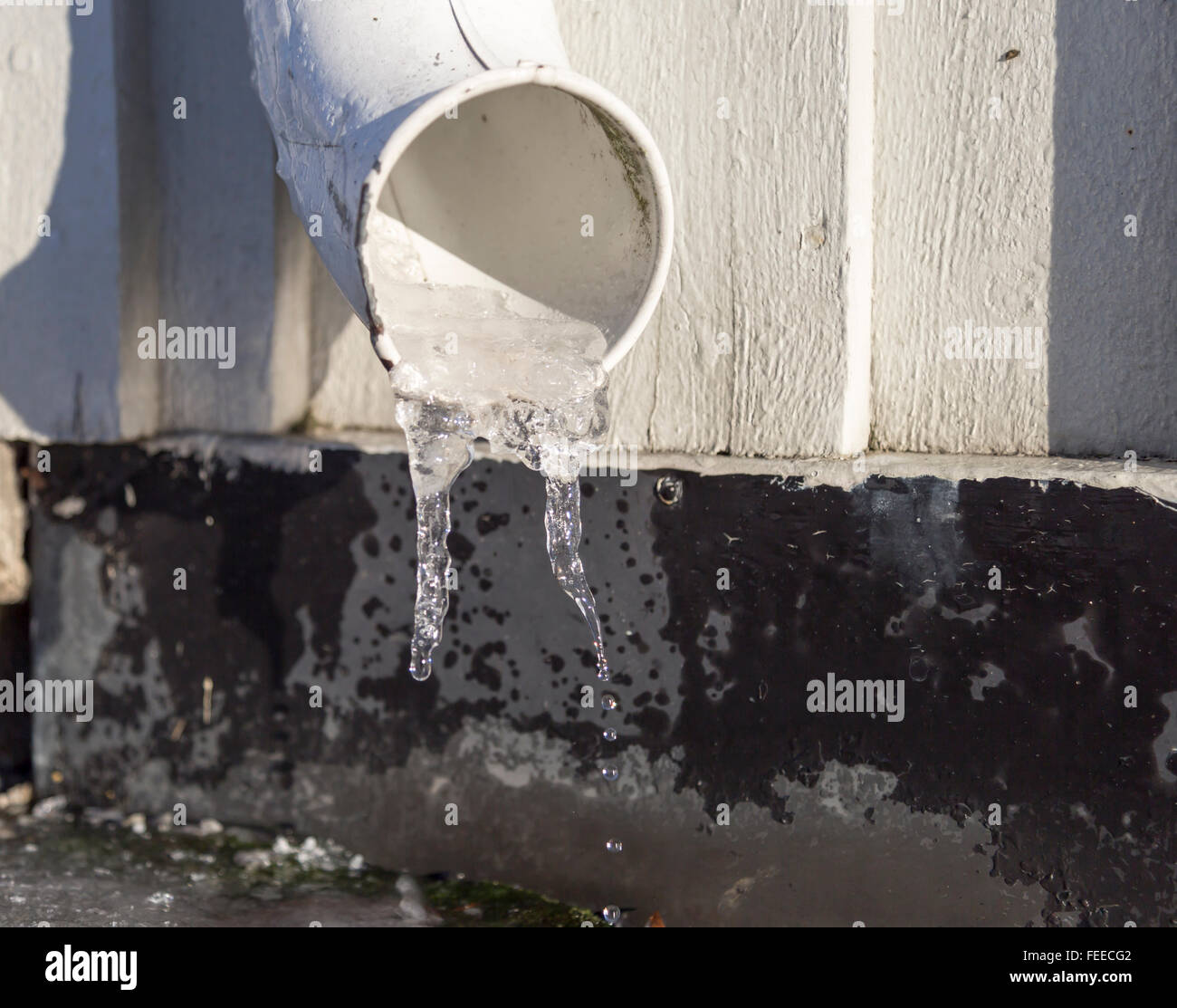 Icicles in Drainpipe with water drops falling from it Stock Photo - Alamy
