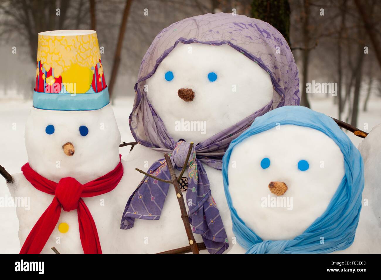 Three snowmen in winter in scarf and hats Stock Photo - Alamy