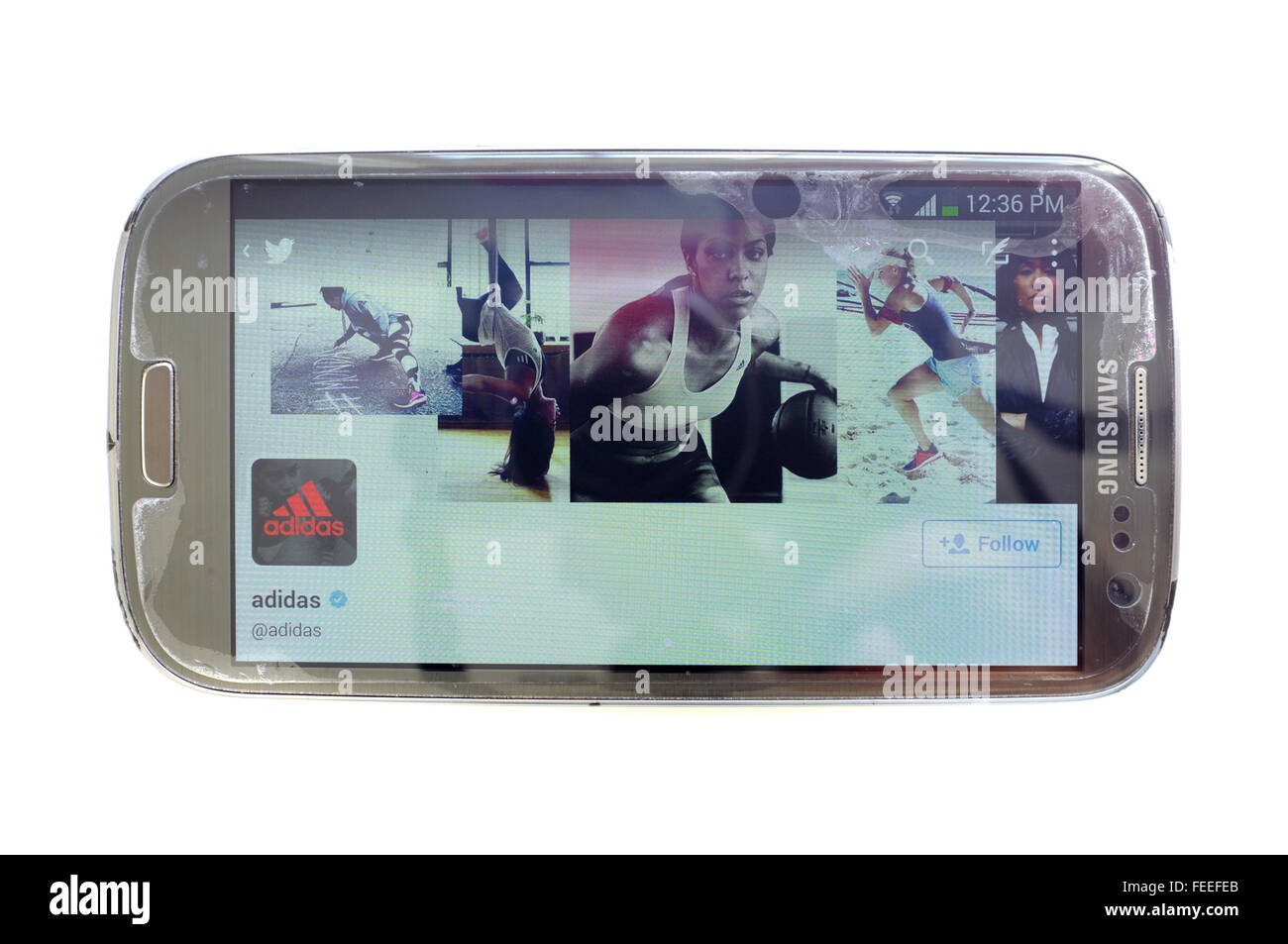 The Adidas Twitter page on a smartphone screen photographed against a ...