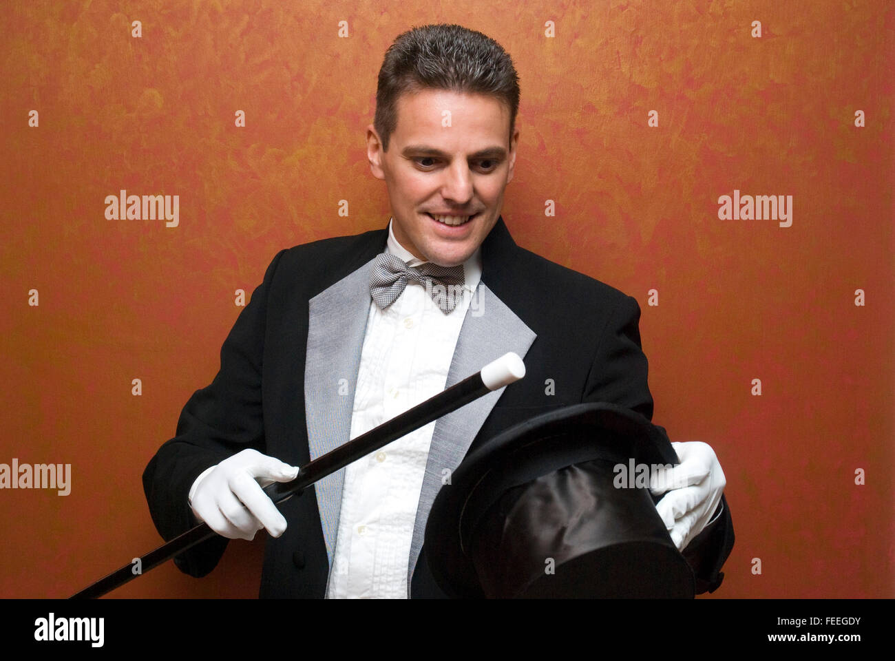 Magician performing with wand Stock Photo - Alamy