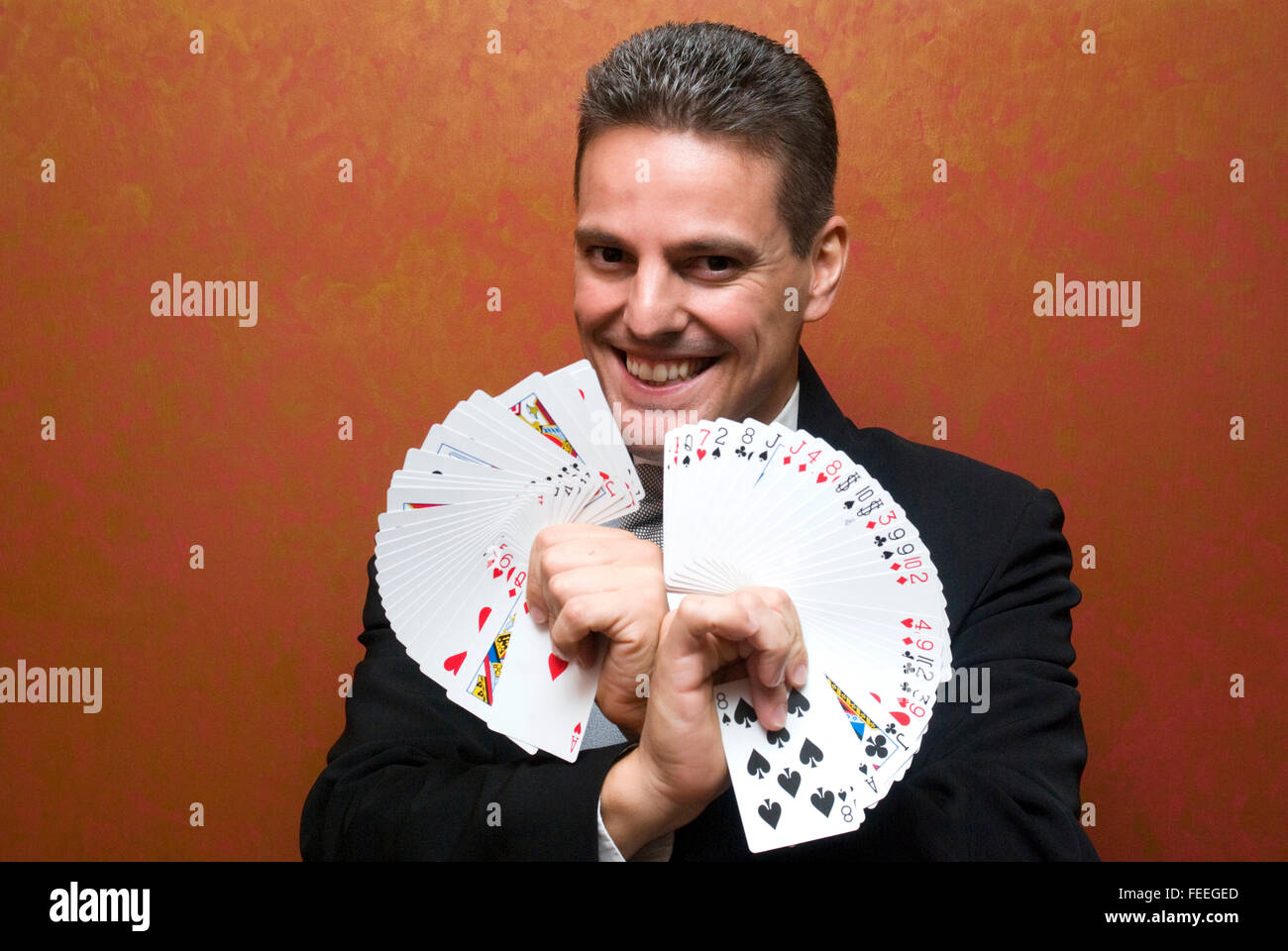 Magician make performance with card deck Stock Photo - Alamy