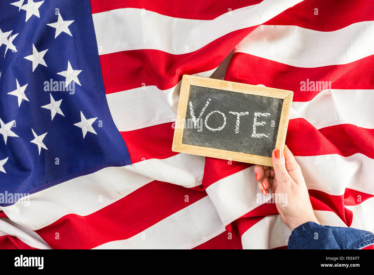 Vote sign on chalk board next to the American Flag Stock Photo - Alamy