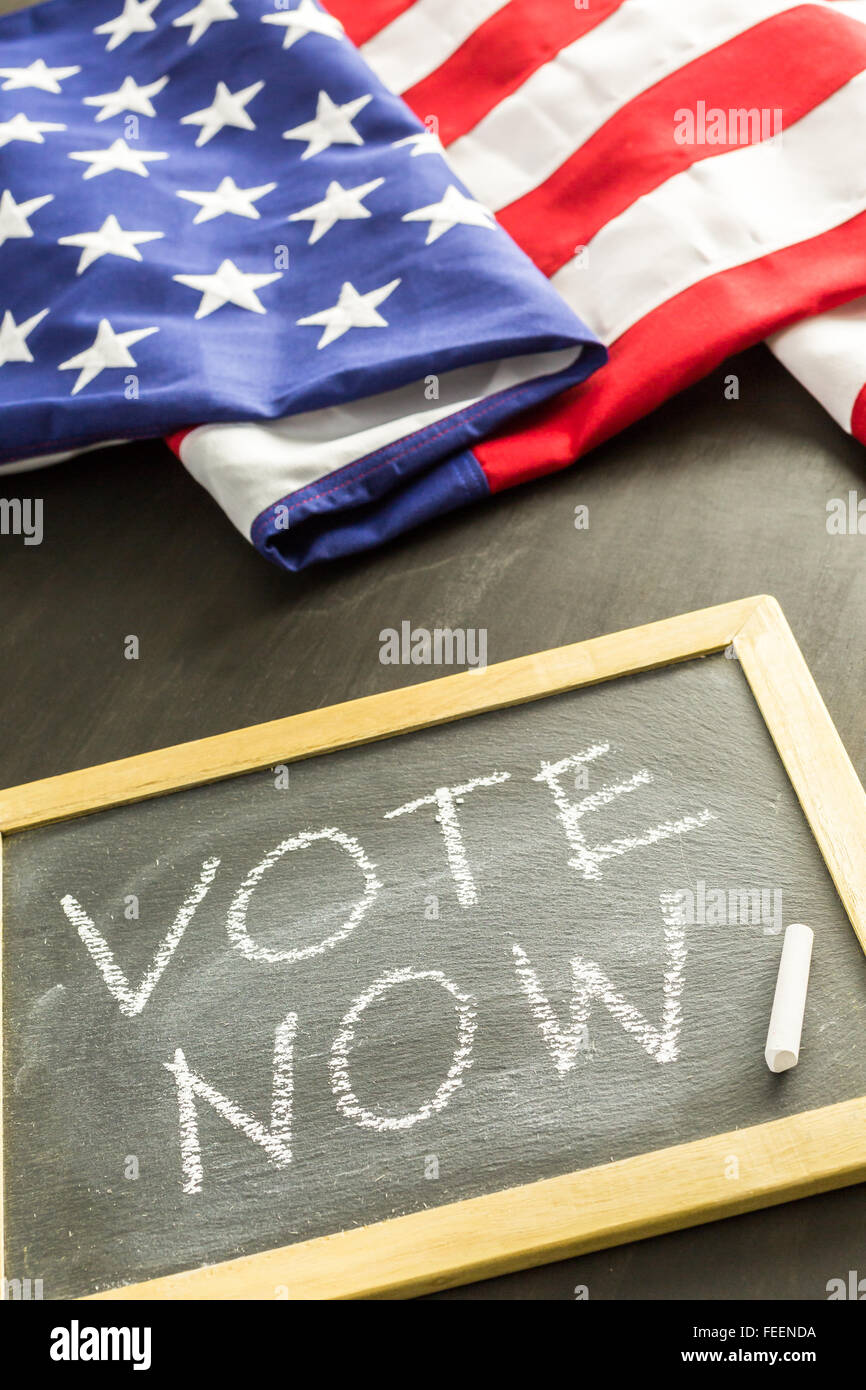 Vote sign on chalk board next to the American Flag Stock Photo - Alamy