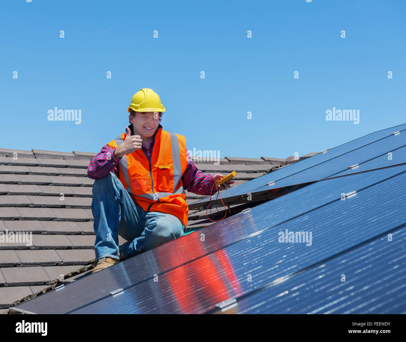 young worker checking solar panels on house roof Stock Photo - Alamy