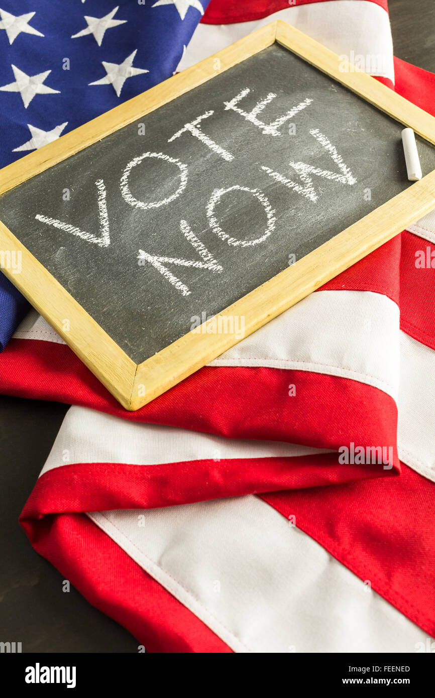 Vote sign on chalk board next to the American Flag Stock Photo - Alamy