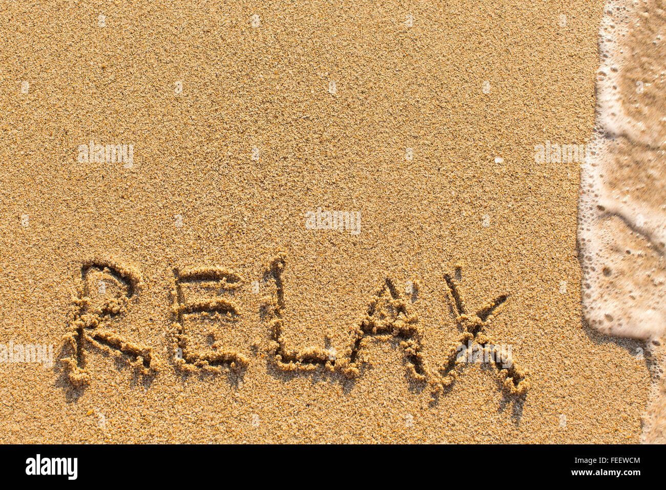 Relax - word drawn on the sand beach with the soft wave Stock Photo - Alamy