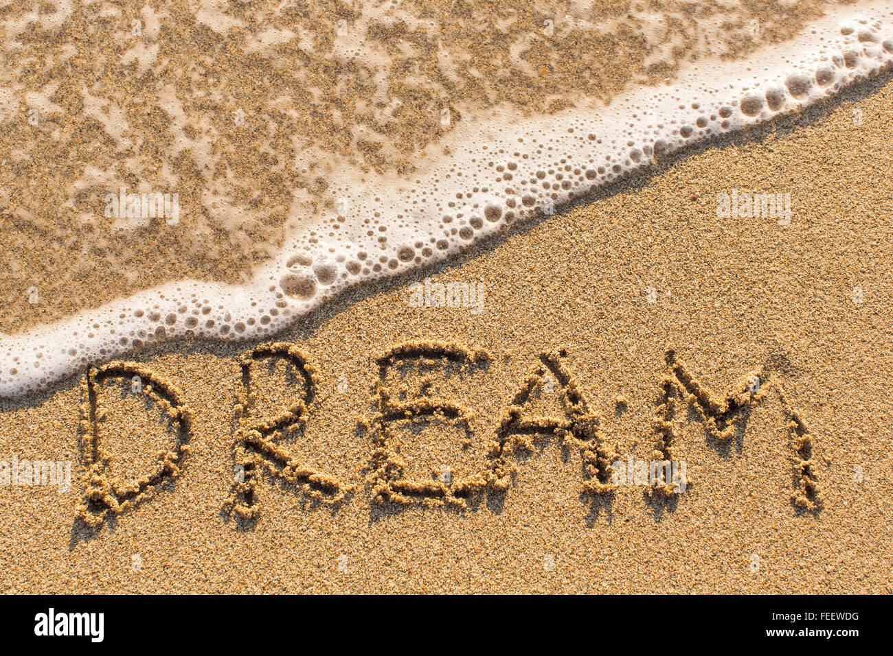 Dream - inscription on sand beach with the soft wave Stock Photo - Alamy