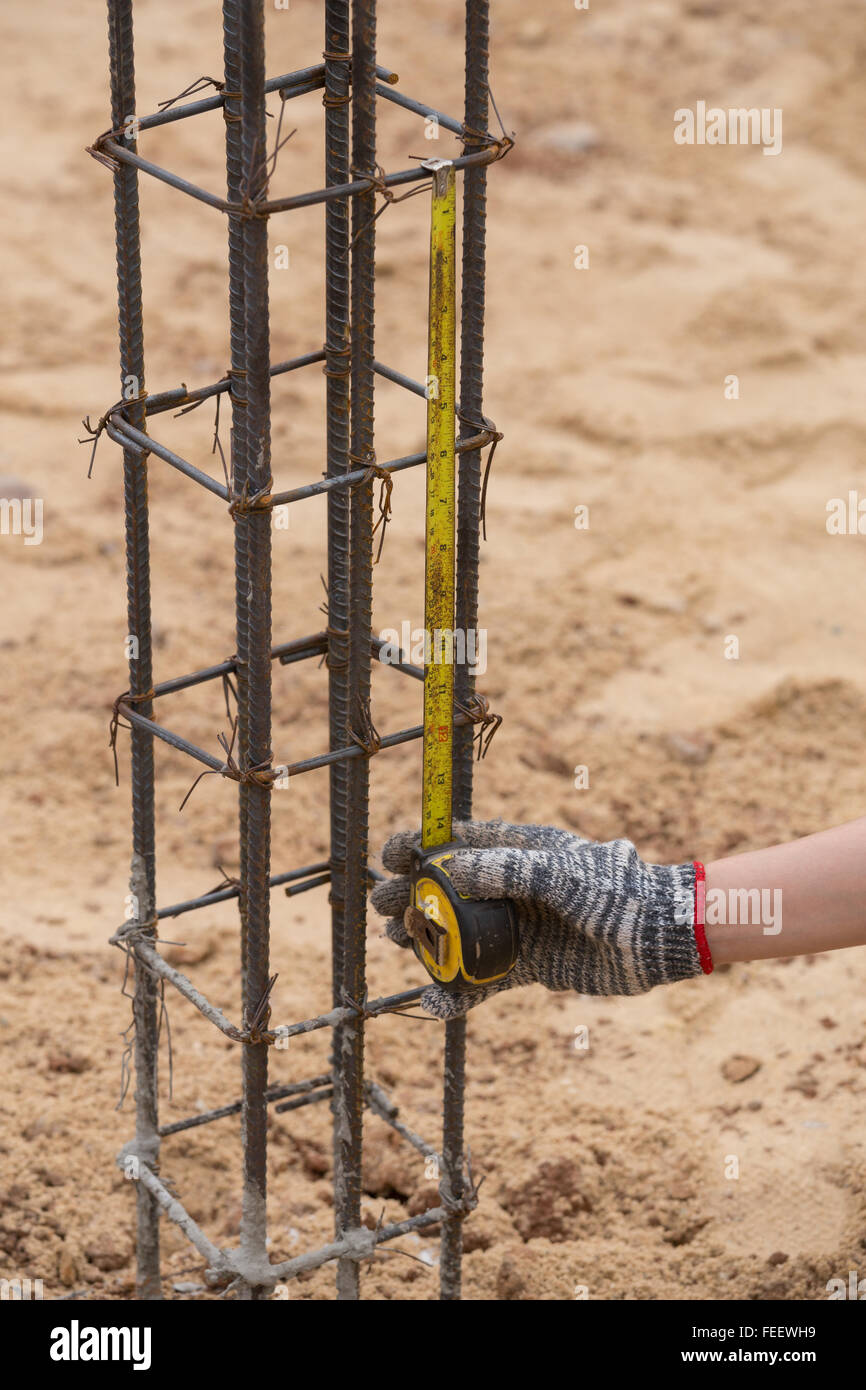 worker measuring steel rod at construction site with tape measure Stock ...