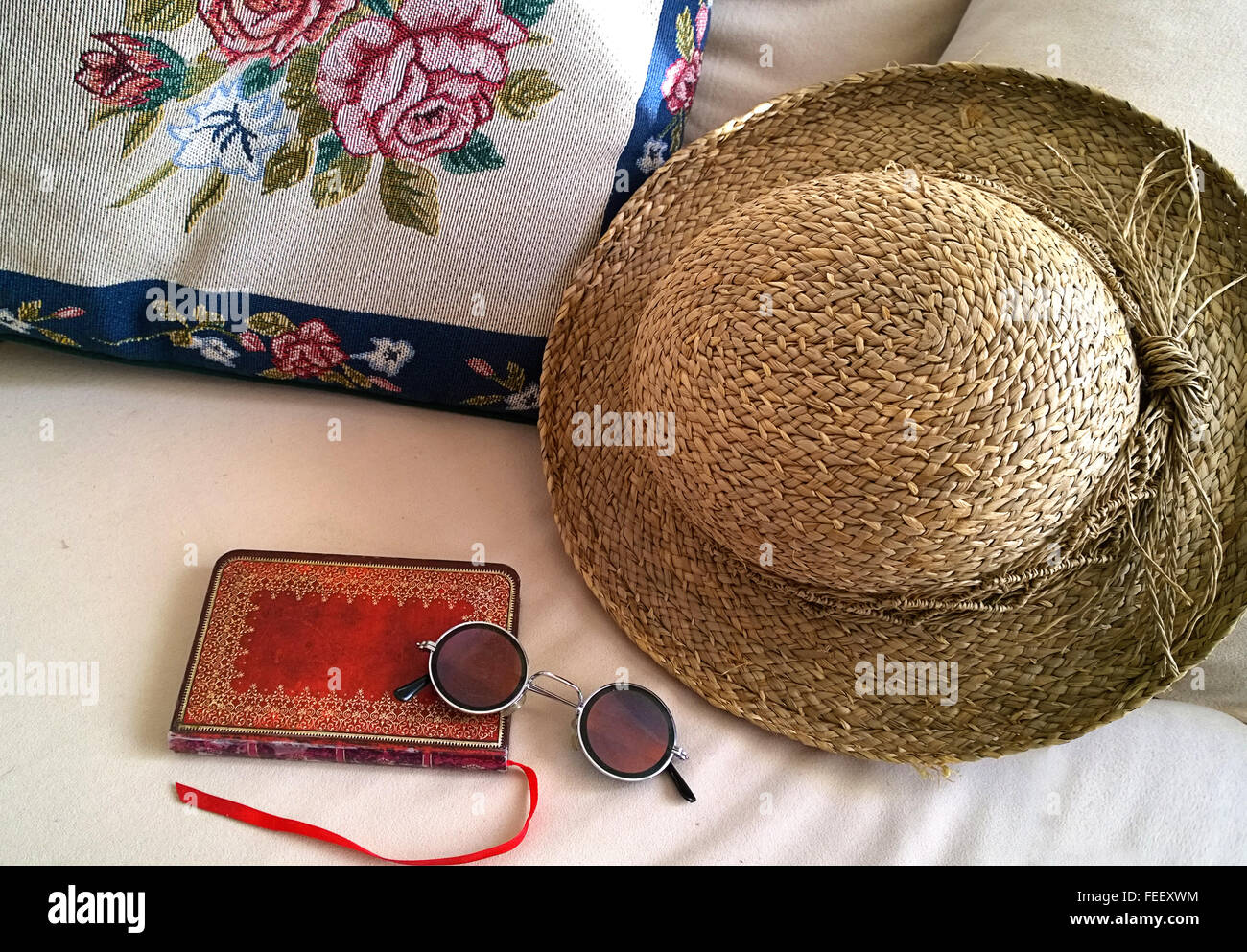 Interiors, vintage still life on couch: woman straw hat , glasses ...
