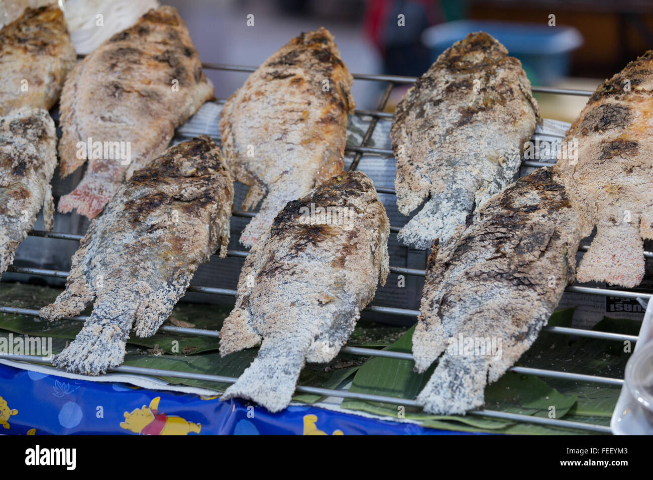 fresh delicious grilled fish, tilapia, nile fish with salt at market ...