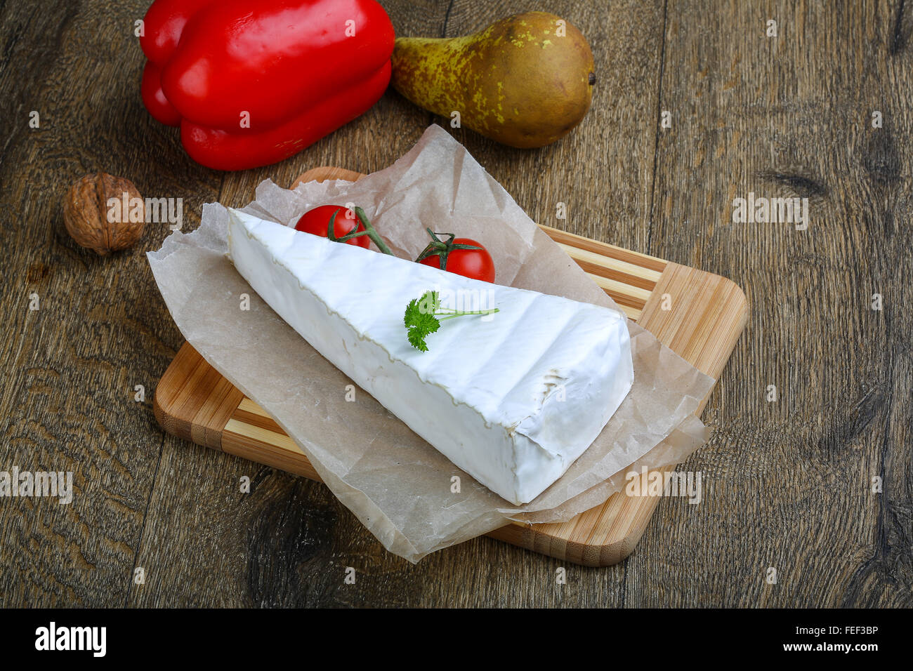 Brie cheese triangle with tomato and parsley Stock Photo - Alamy