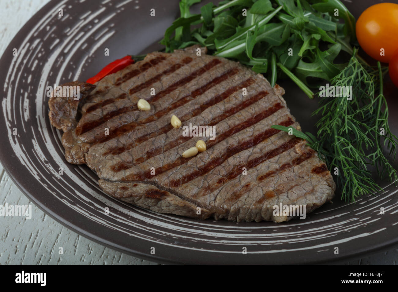 Grilled beaf steak with rucola and dill leaves Stock Photo - Alamy