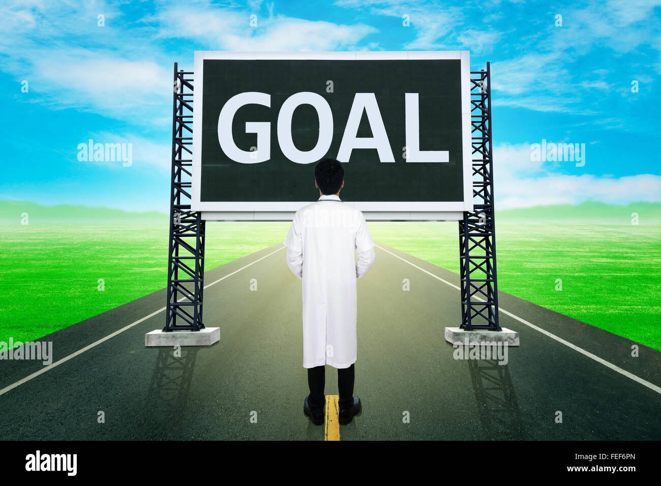male doctor standing on road and looking with large sign of goal Stock ...