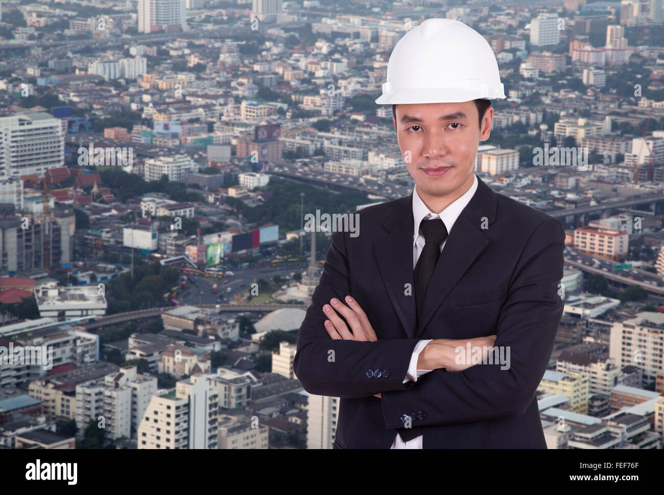 engineer in white helmet with arms crossed, city background Stock Photo ...