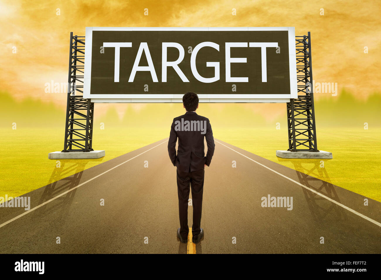 businessman standing on road and looking with large sign of target at ...