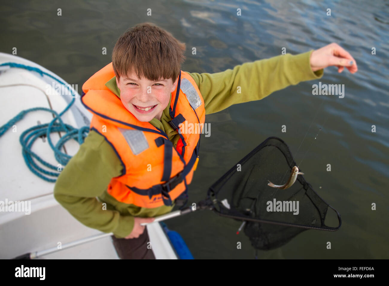 Boy fishing from a boat on the Norfolk Broads Stock Photo - Alamy