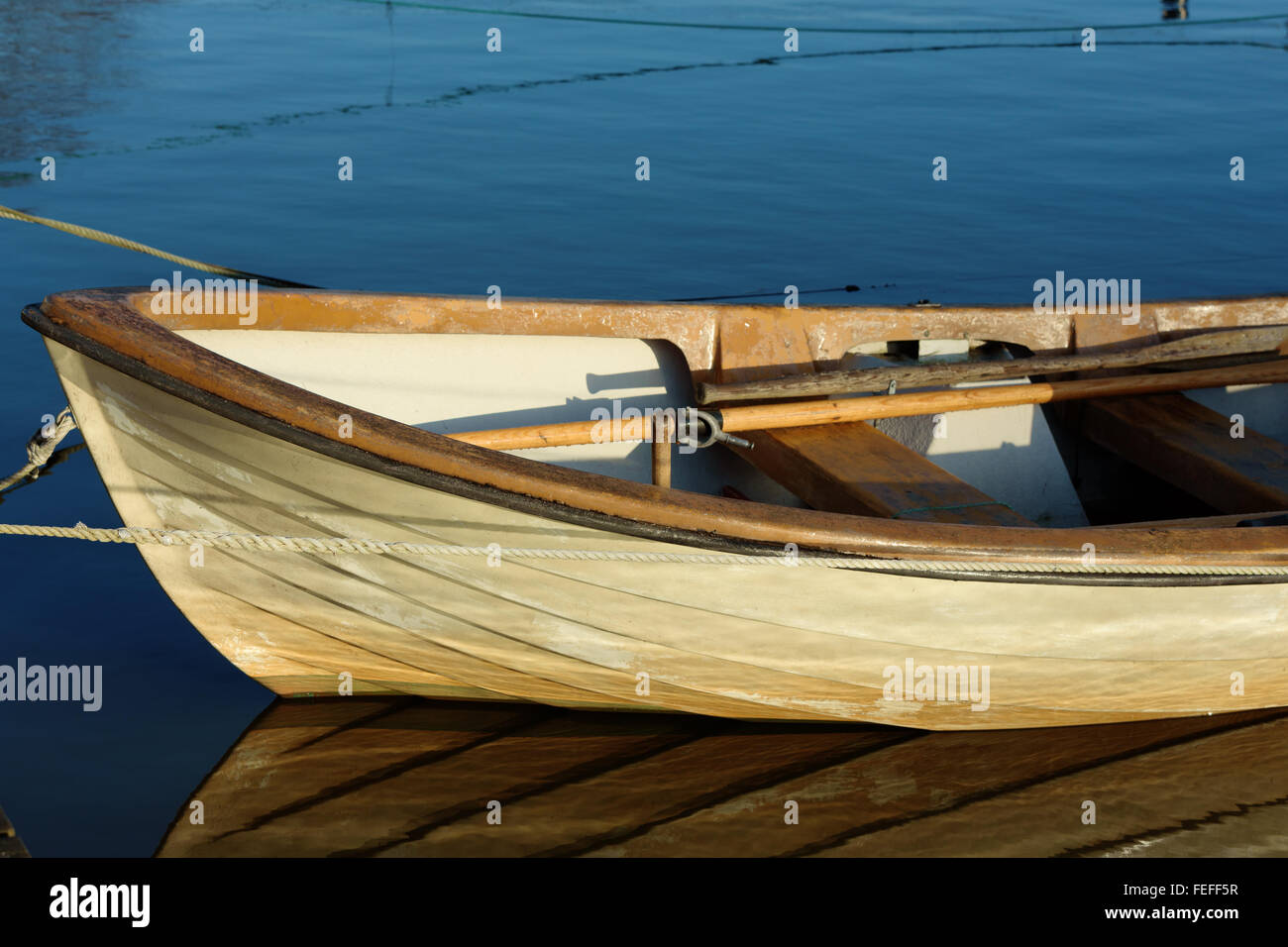 The fore of a small plastic rowboat in the water. Keel is weathered and ...