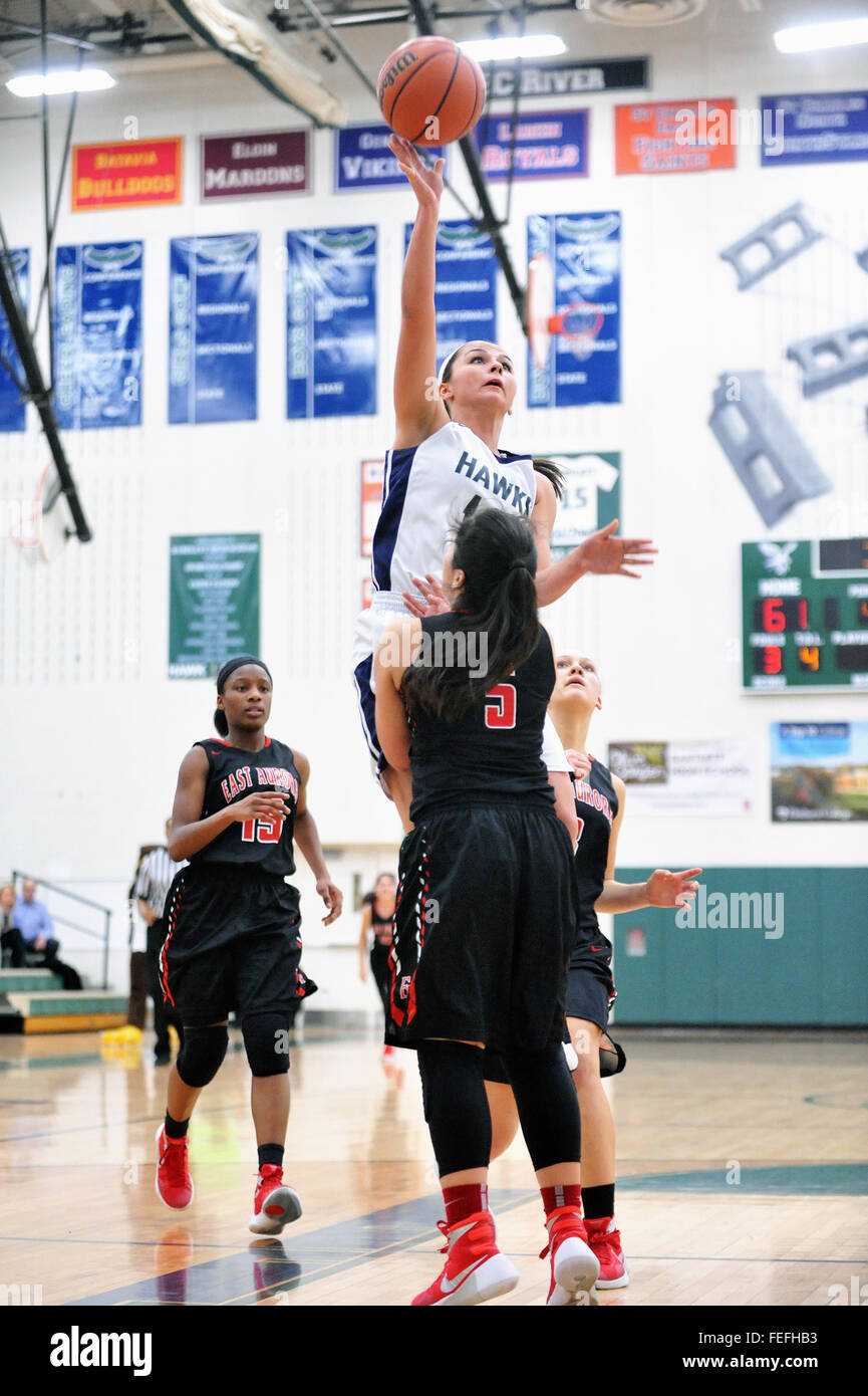 An airborne player shooting well above a defender braced to take ...