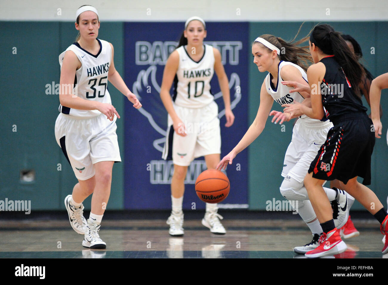 Player dribbling out from under her own basket after securing a loose ...