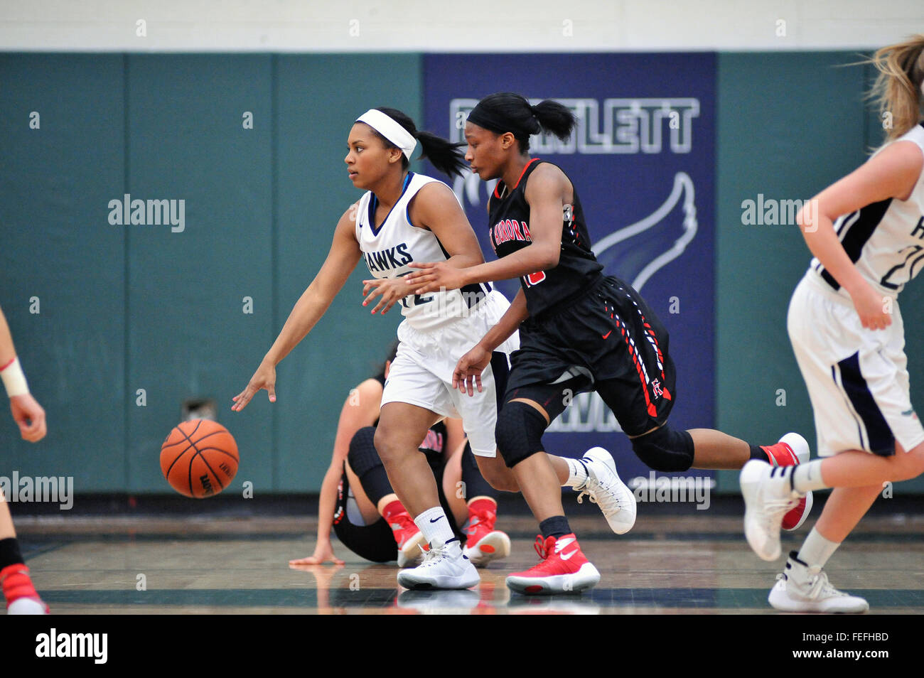 Player dribbling out from under her own basket after securing a loose ...