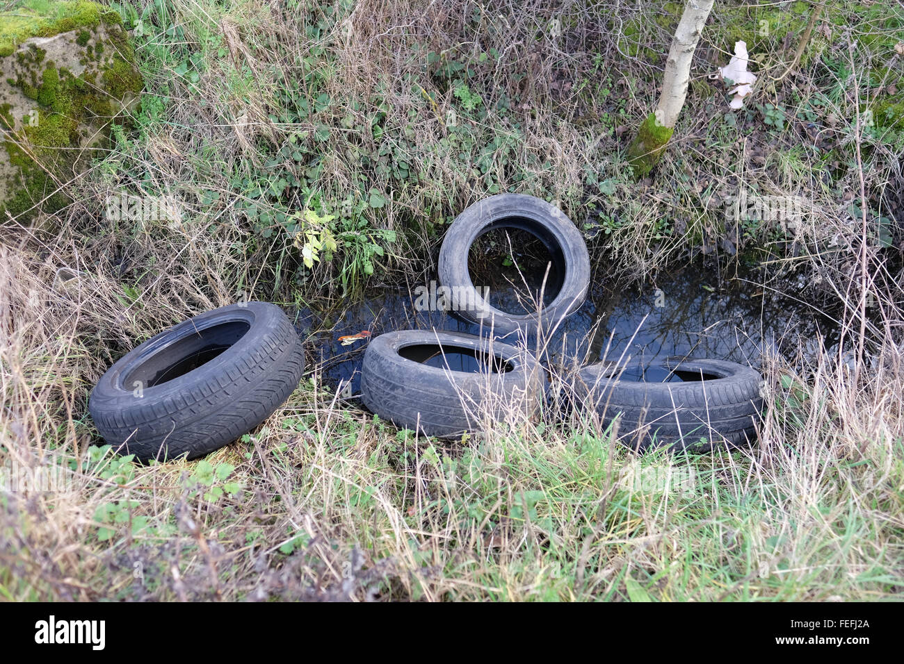 tyres dumped in a ditch Stock Photo - Alamy