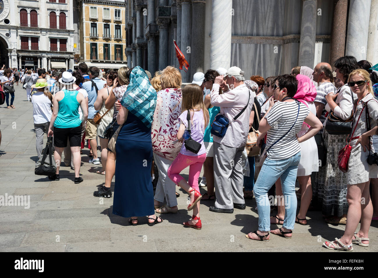 A long queue of tourists waiting patiently outside the Basilica di San ...