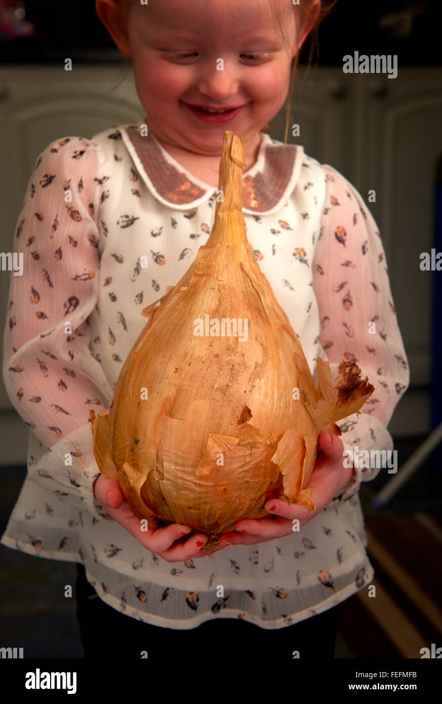 A happy 3 year old girl holding a prize winning onion Stock Photo - Alamy