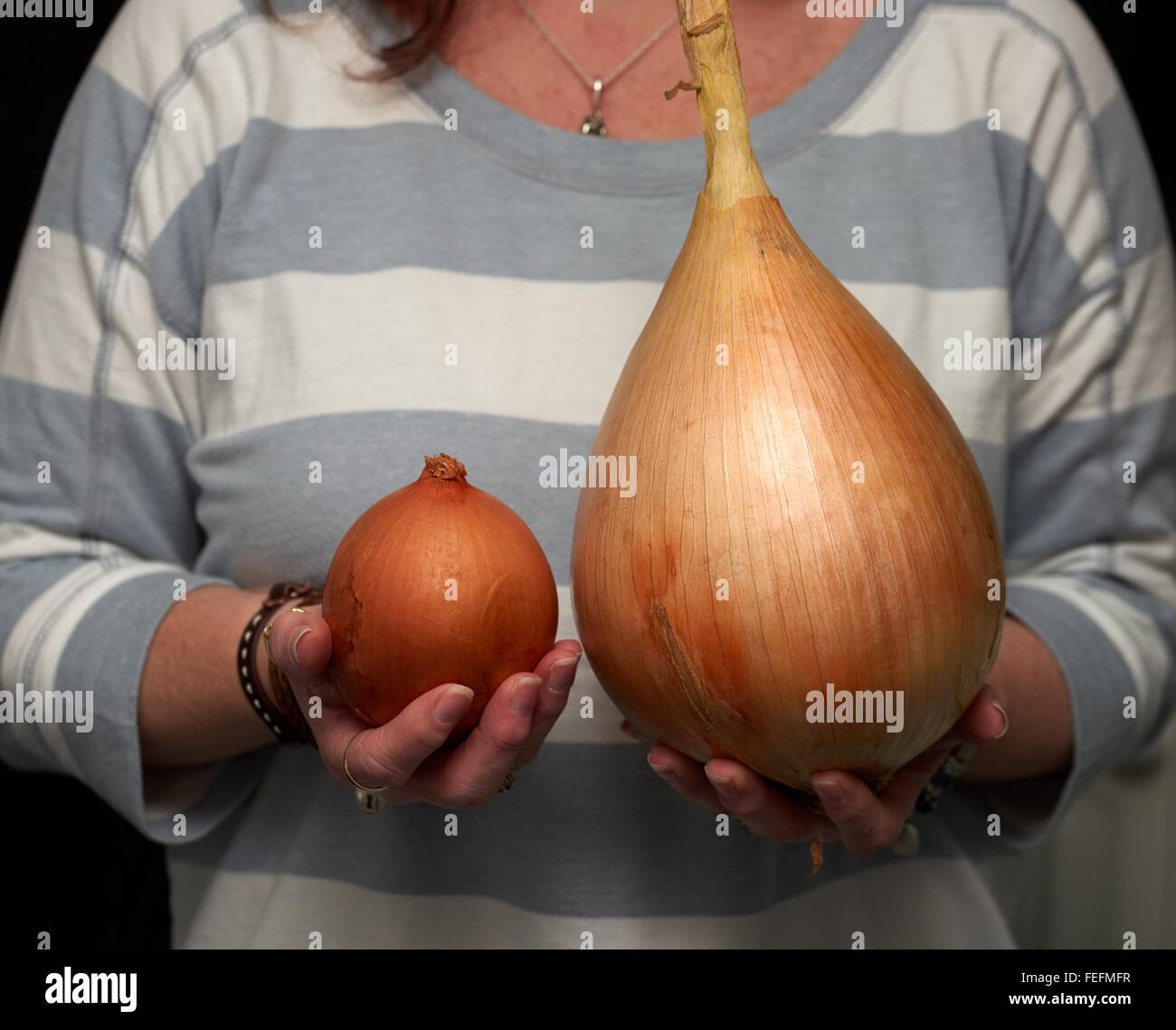 An adult female holding a prize winning onion and a standard ...