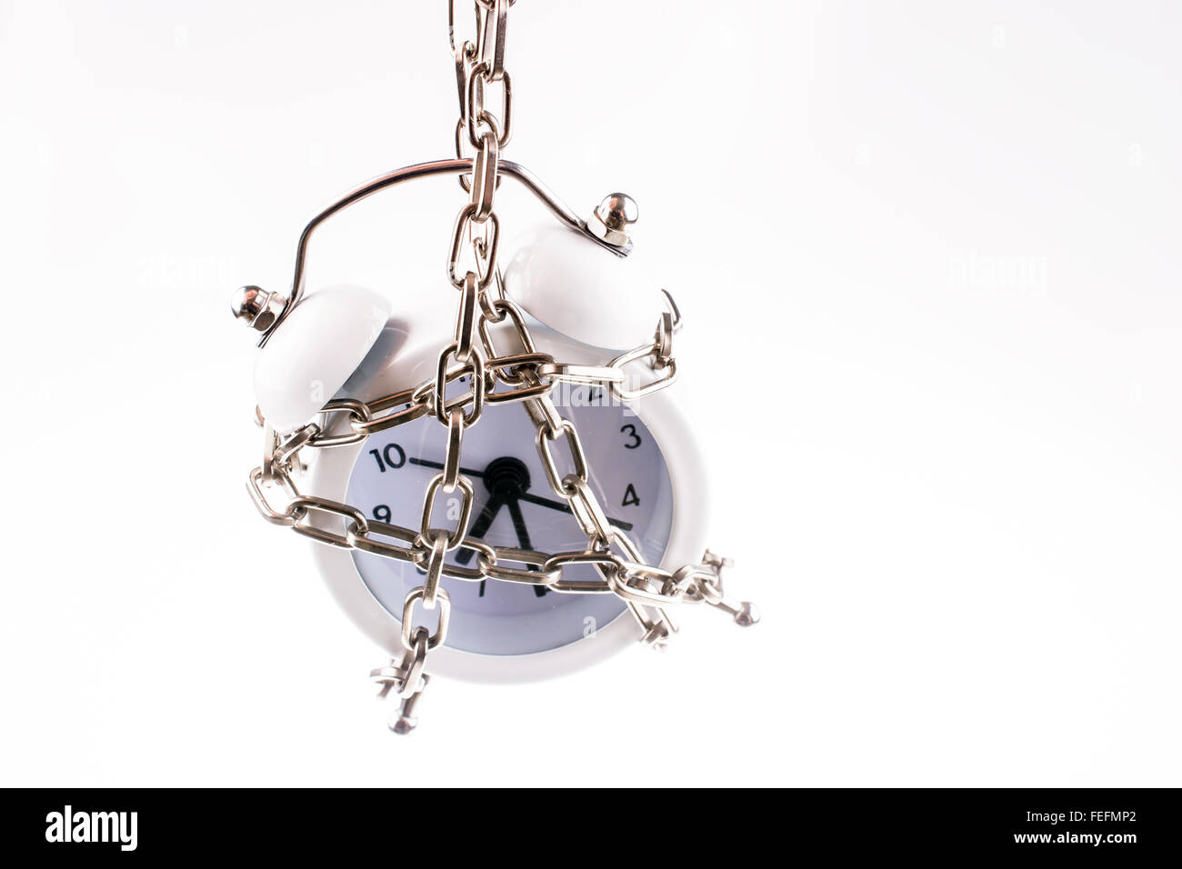 White color alarm clock in chain on a white background Stock Photo - Alamy