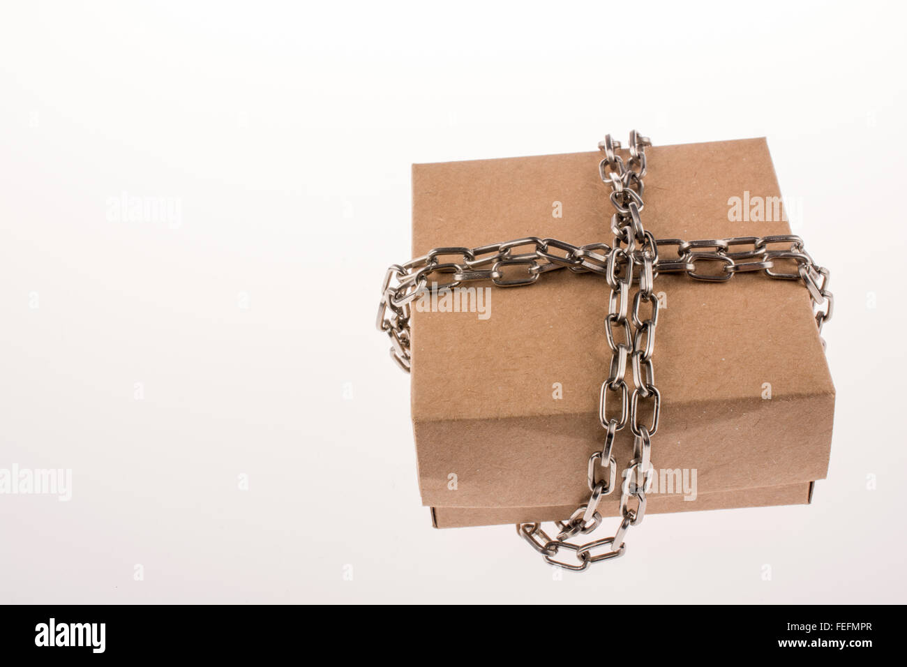 Cardboard Box in chains on a white background Stock Photo - Alamy