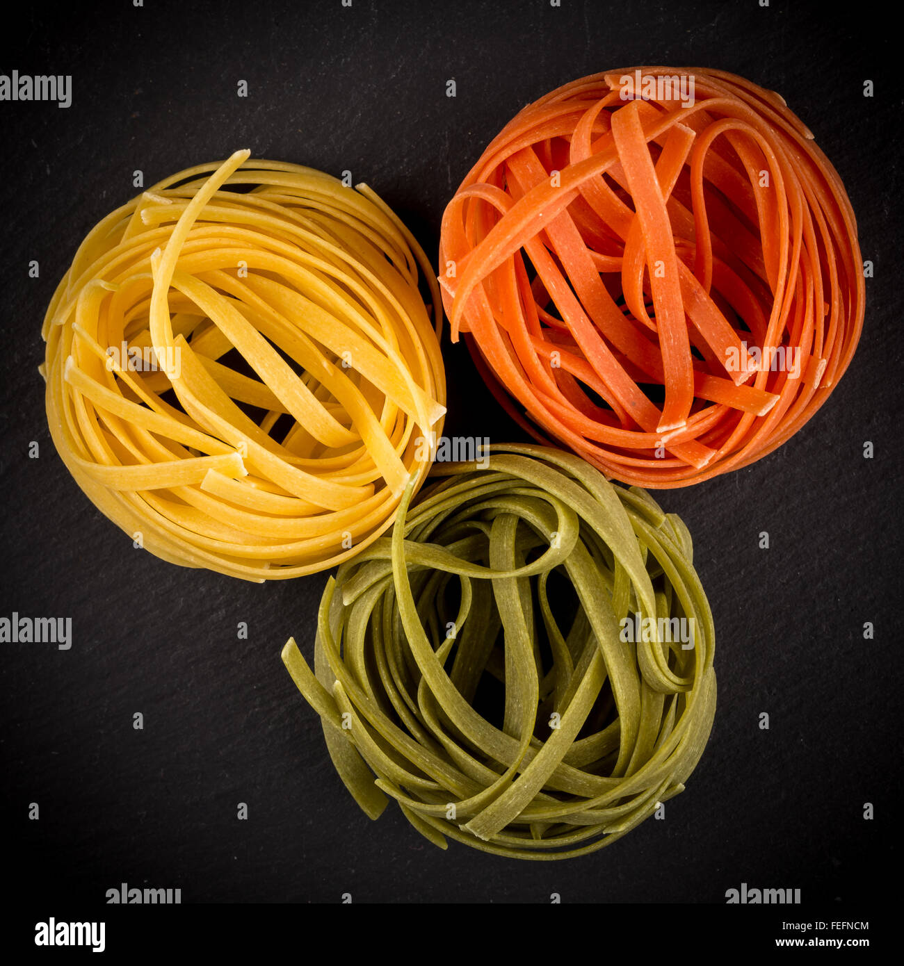 Four colour roll nest pasta on a white background Stock Photo - Alamy