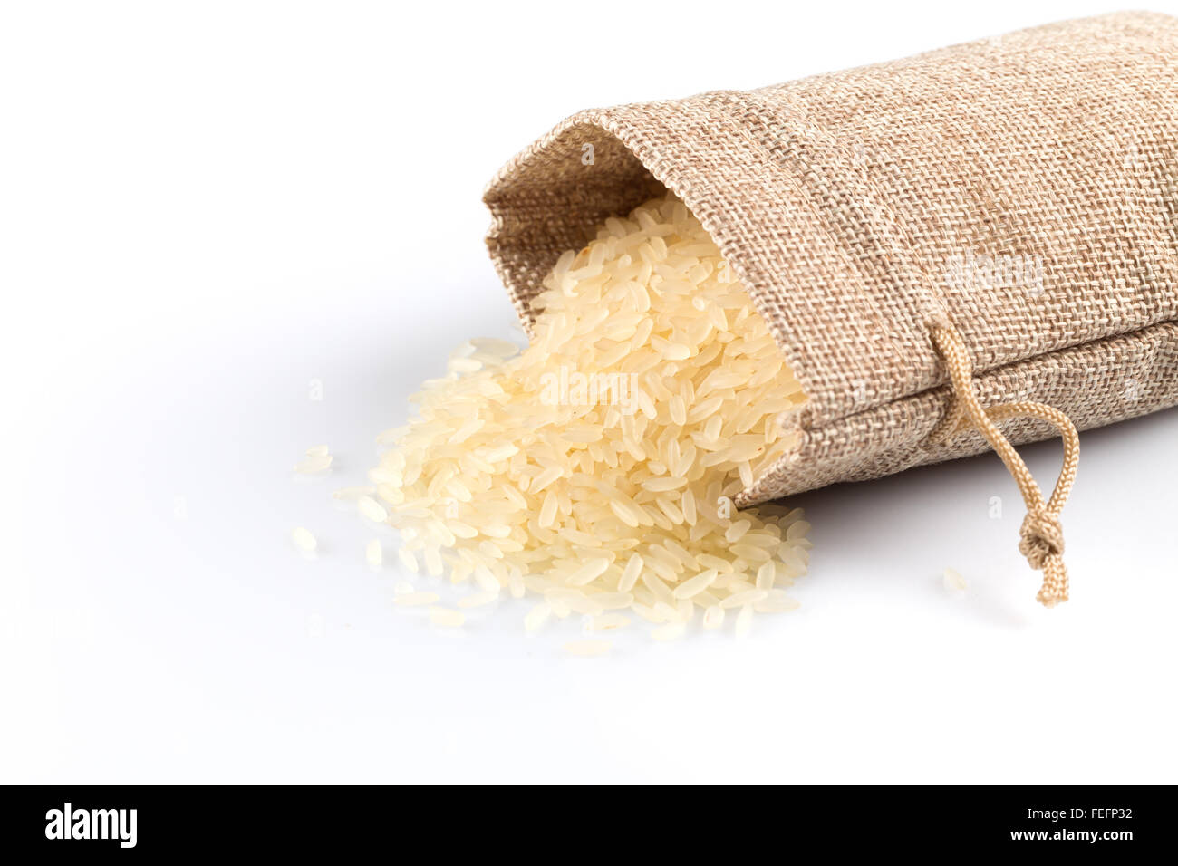 Rice in a sack and spilled on a white background Stock Photo - Alamy