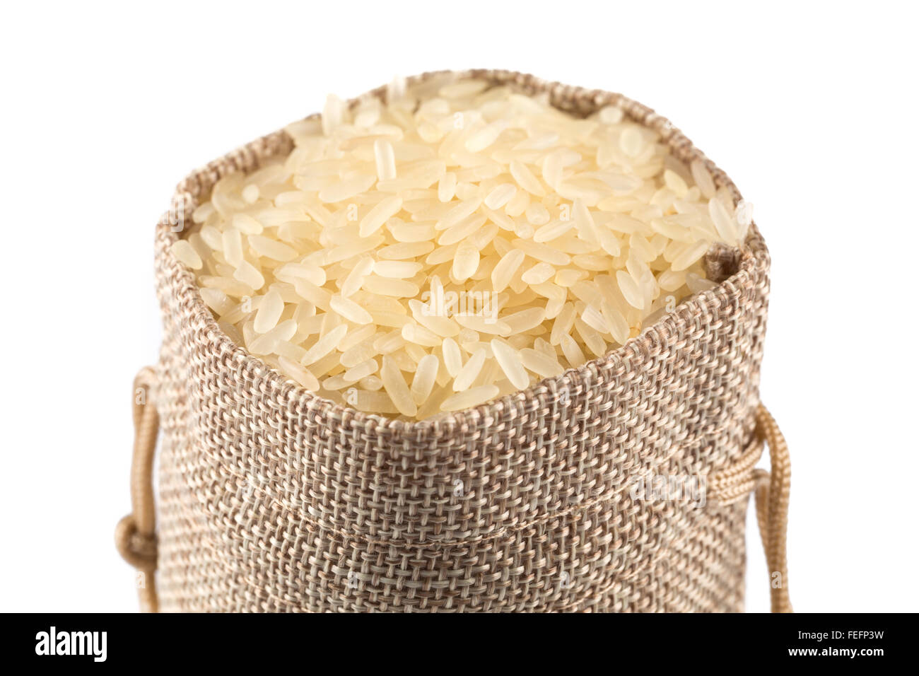 Rice in a sack and spilled on a white background Stock Photo - Alamy