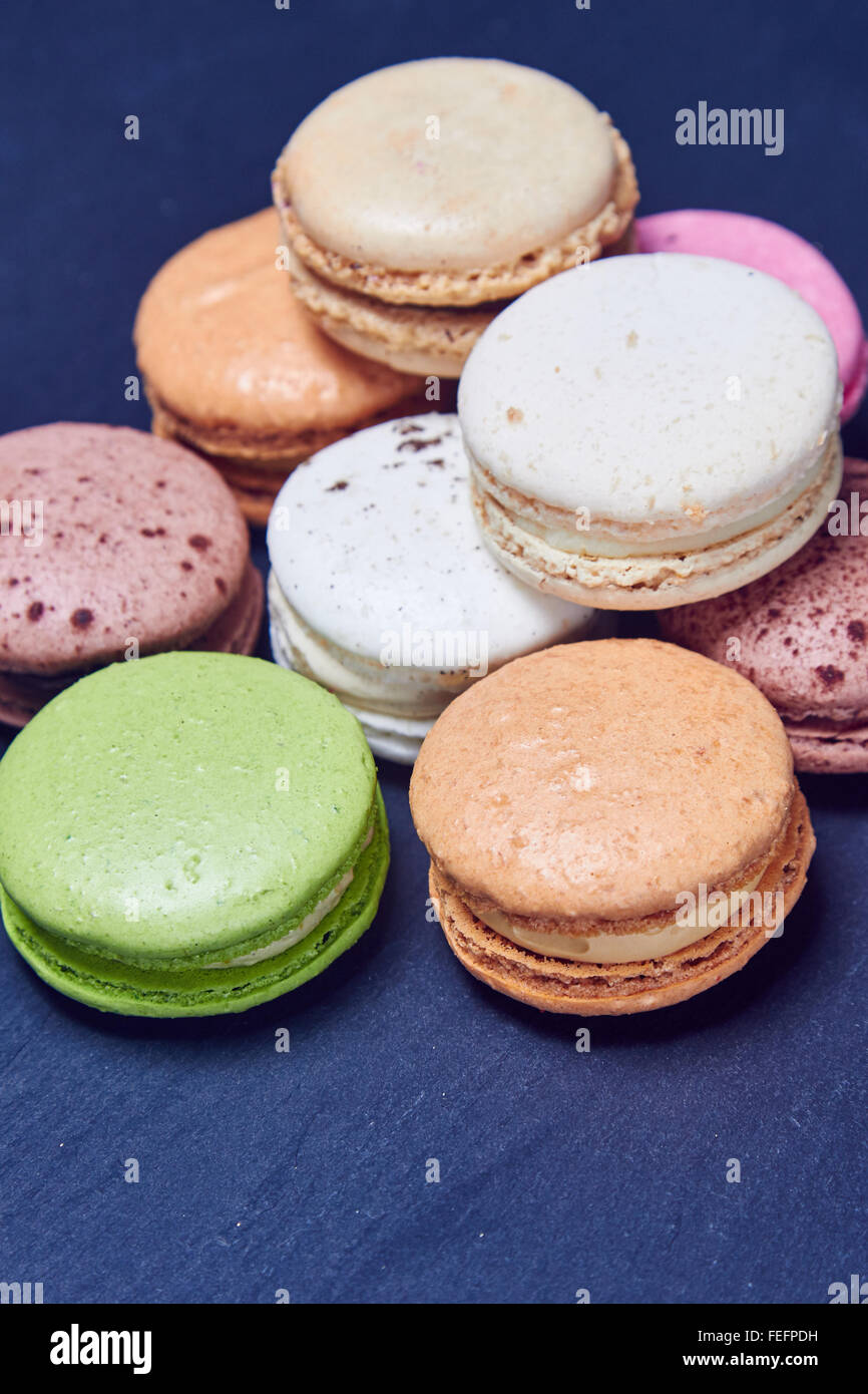Colorful macaroons sweets on a dark background Stock Photo - Alamy