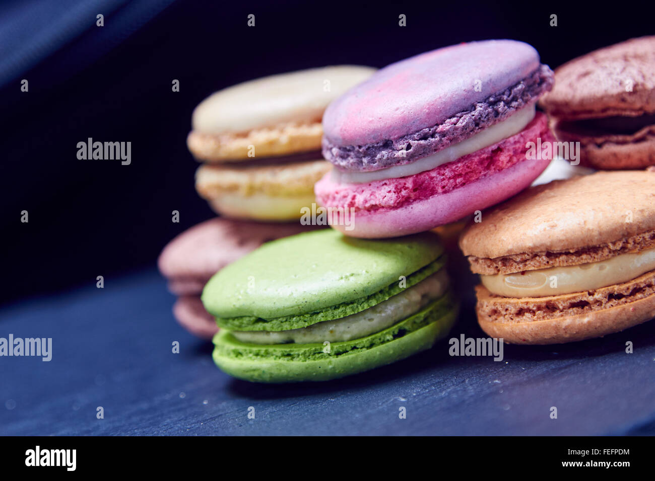 Close up view with macaroons in great detail, stack on a dark ...