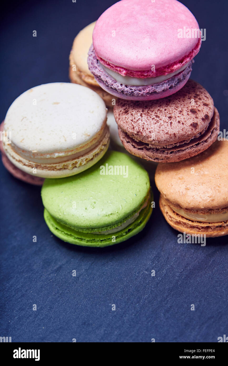 Top view showing stack of macaroons on a black slate, in different ...